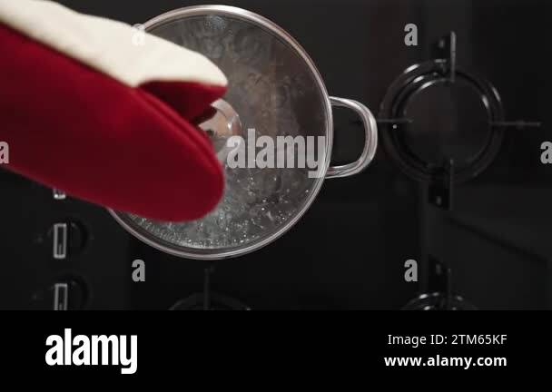 From a top view, I see a pot on a gas stove with boiling water inside ...