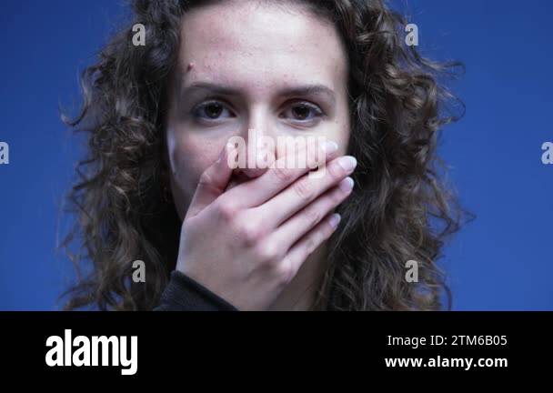 Scared woman reacts with shock and unbelief by covering mouth feeling ...
