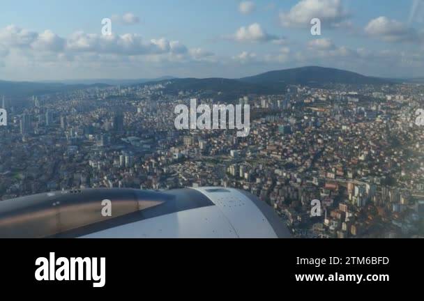 A passenger plane flies over Istanbul, the capital of Turkiye. Houses ...