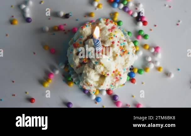 Top view muffins with candles on the turntable, confetti pudding pie ...