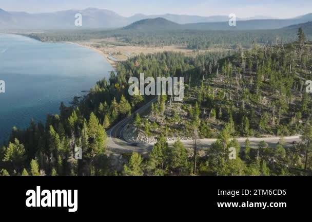 Mountain forest lake Tahoe landscape car driving by forest hill. Aerial ...