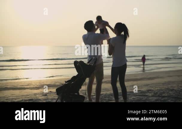 Tourism concepts of 4k Resolution. Asian father and mother holding his child on the beach Stock ...