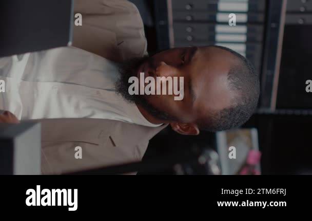 Vertical video: African american law agent studying crime scene photos ...