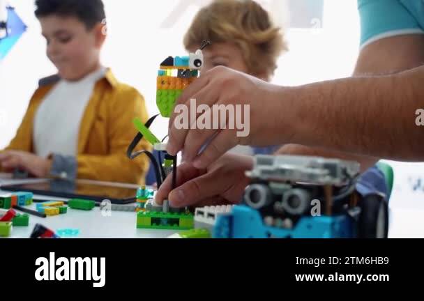 Robotics programming class. Children construct and code Robot. STEM education using constructor ...