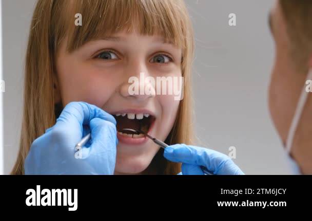 The doctor examines the childs teeth. A childrens dentist examines a ...