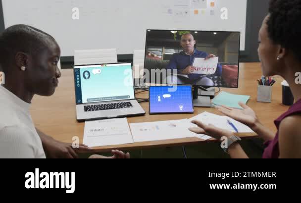 Diverse businesswomen in office using computers with video call and ai ...