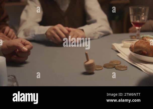 Close-up shot of hands of unrecognizable Jewish family sitting together ...