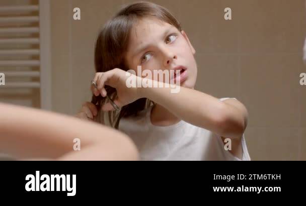 Reflection in the mirror. Child cuts hair in protest. Lifestyle haircut ...