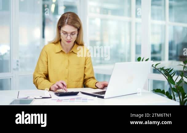 Busy blond mature business woman financial analyst accountant ... Busy blond mature business woman financial analyst accountant ...