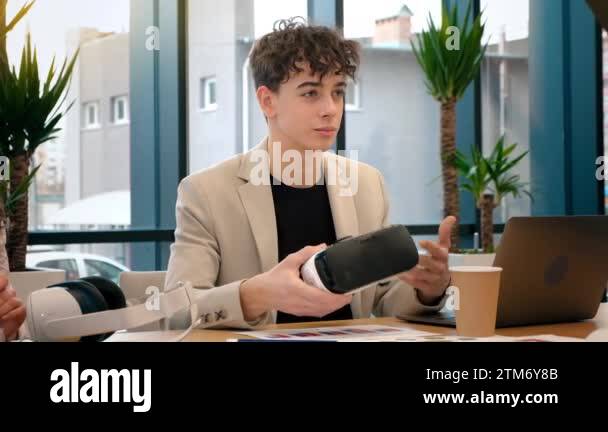 Business conference in VR in an office. A young man explaining others ...