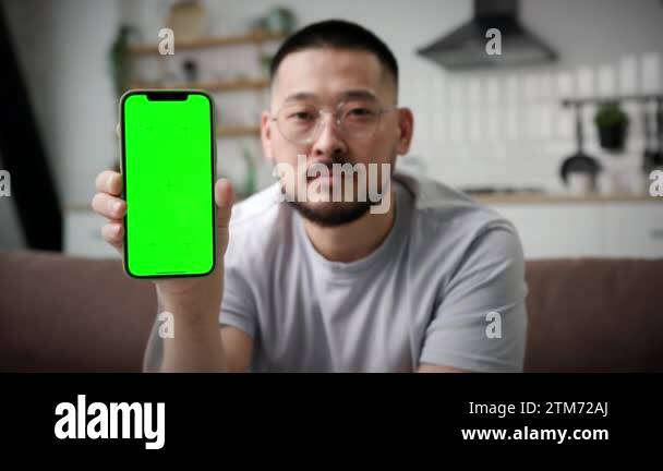 Man In Googles Holding Green Screen Mobile Phone At Camera. Smiling ...