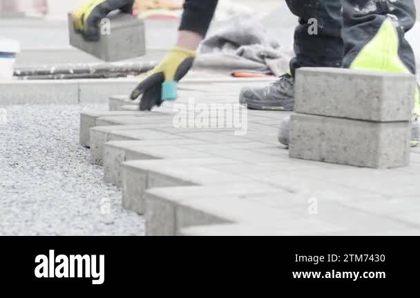 laying interlocking pavers during the construction of sidewalks and ...