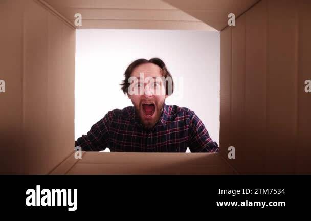 Wow emotions. Extremely excited young man emotionally opening cardboard ...