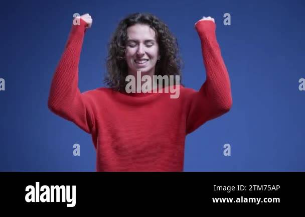 Woman celebrating success by raising fist in the air feeling delight ...