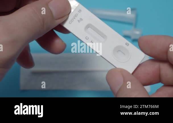 POV of Man hands using Rapid antigen test kit or ATK and blue ...