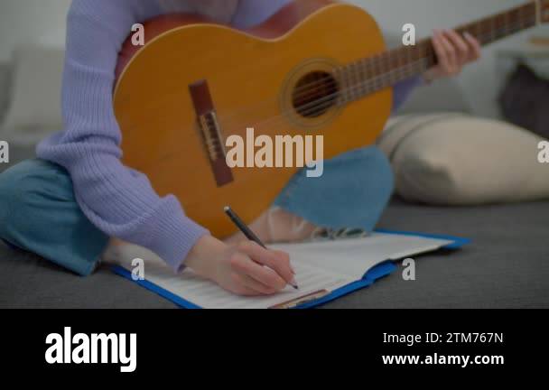 Close-up of talented female songwriter playing on acoustic guitar ...