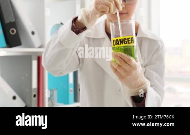 School girl wearing protection glasses makes chemical reaction during ...