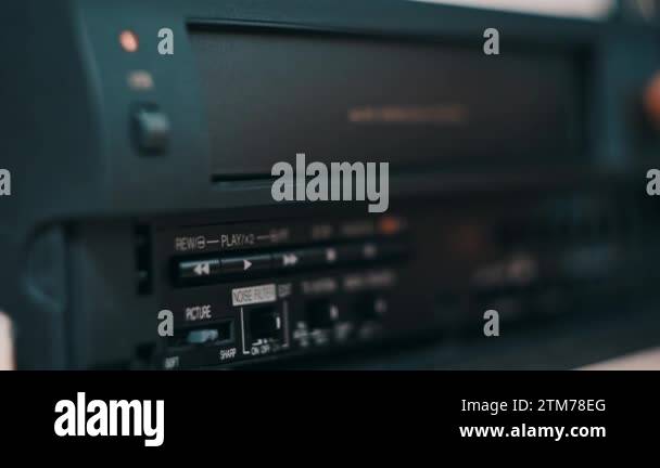 Eject VHS tape cassette from VCR player. Male hand pushes a button and ...