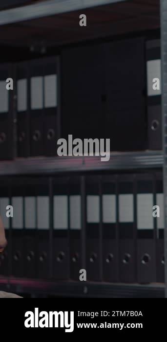 Vertical video: Law officer examining physical evidence in case files ...