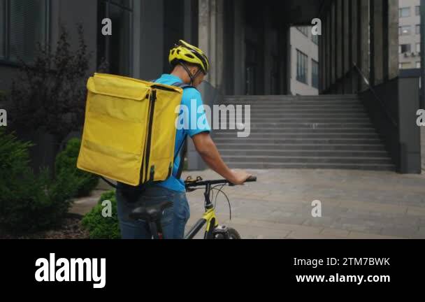 Back View of the African American Courier Walking near office Building ...