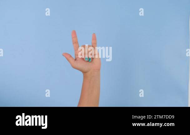 Female hand showing I Love You sign isolated on pastel blue background ...