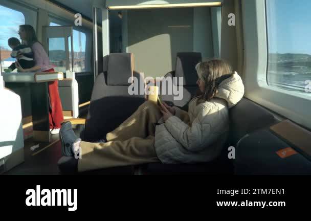Teenage girl traveling on high-speed express train, scrolling through ...