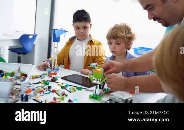 Robotics programming class. Children construct and code Robot. STEM education using constructor ...