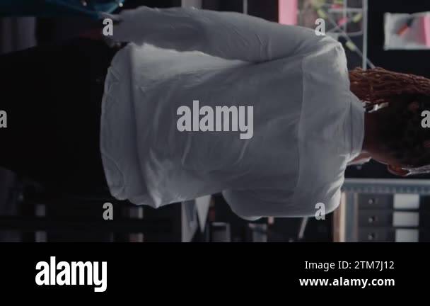 Vertical video: Detective inspector examining case information on map ...