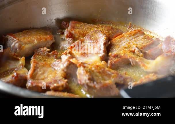 Searing beef bottom round roasted meat in cast iron skillet in boiling ...