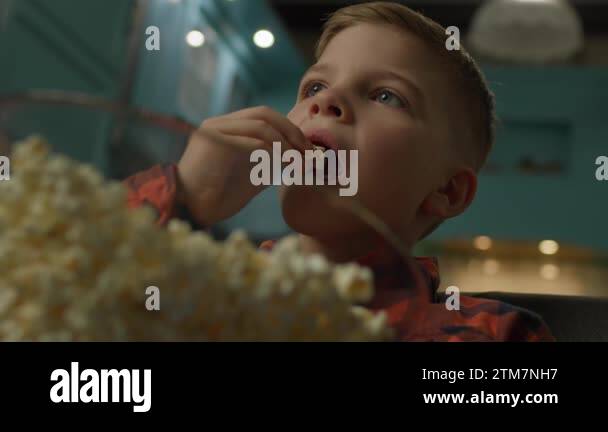 Kid Eating Popcorn At Home Close Up. Boy watching TV with popcorn ...
