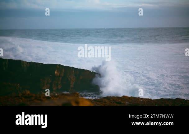 Beautiful waves crashing rocky shore. Foaming sea washing hitting wild ...