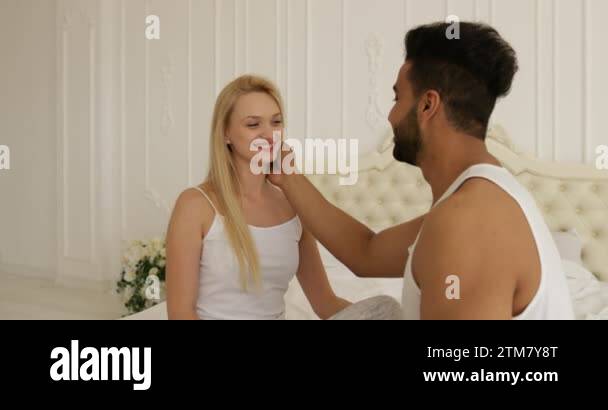 Couple love embrace smile sitting bed face to face mix race man ...