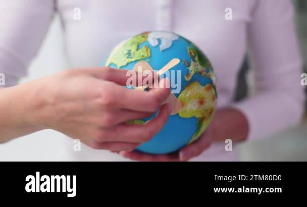 Woman holding globe of planet Earth with adhesive plaster. Pandemic and ...