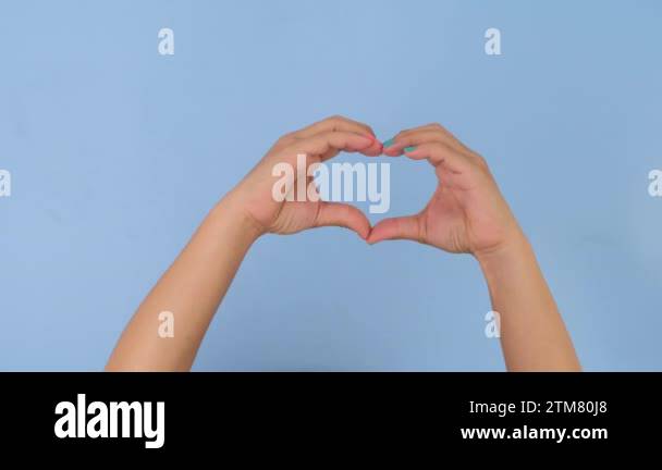 Female hand showing heart shape, love and sympathy symbol on pastel ...