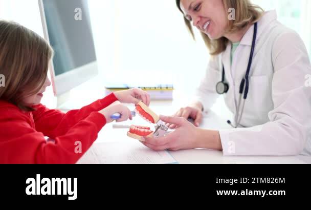 Dentist teaches child daughter oral hygiene in dental clinic. Proper ...
