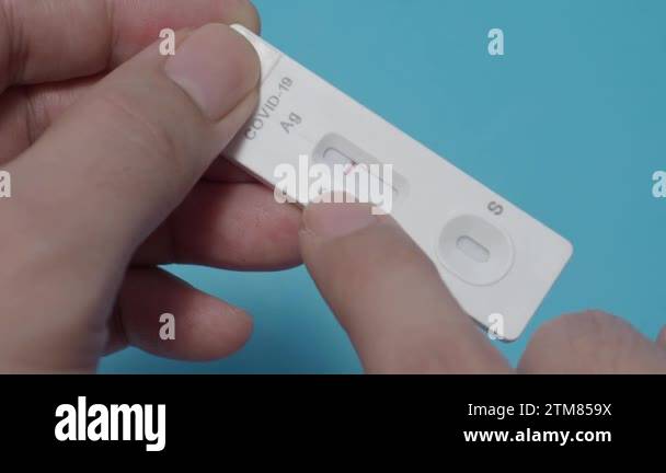 POV of Man hands using Rapid antigen test kit or ATK and blue ...