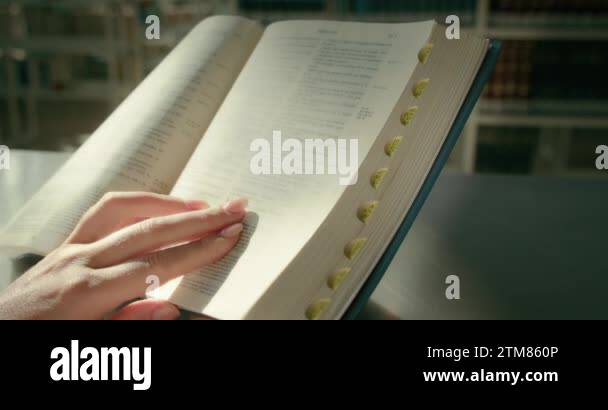 Womans finger points to and reads biblical scripture in gospel of John ...
