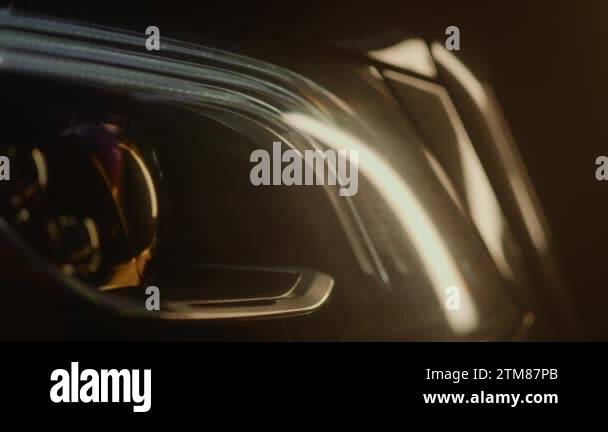 Headlights of prestigious black luxury modern car lighting up, close up ...