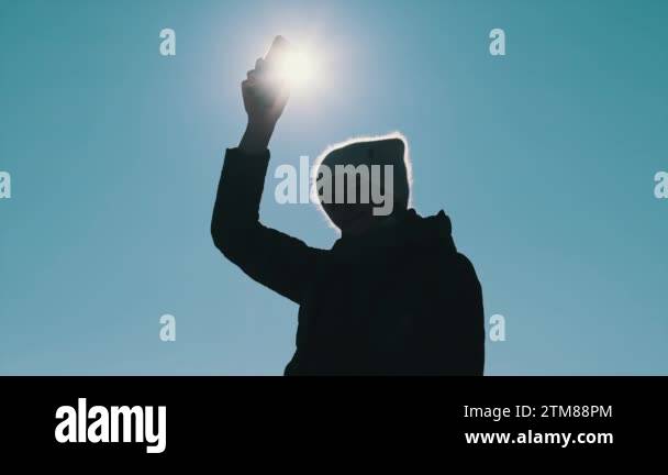Woman tries to catch a mobile signal by holding up her smartphone ...