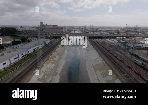 Forwards fly above Los Angeles river flowing in artificial concrete ...