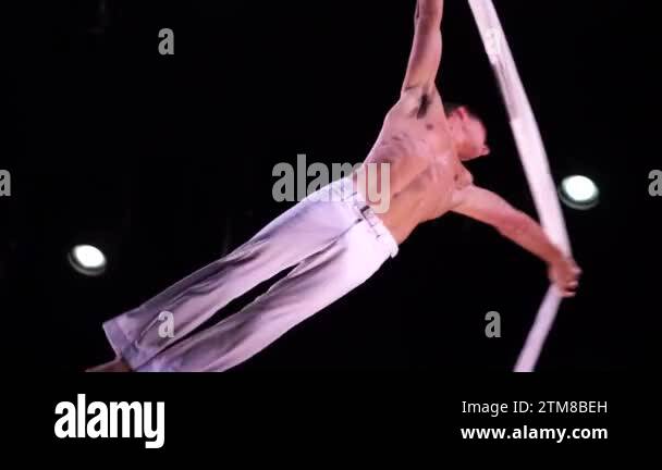Male, muscular circus artist on Aerial straps on black stage background ...