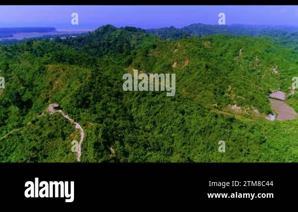 A narrow path runs through the green hills. 4K drone footage. This is ...