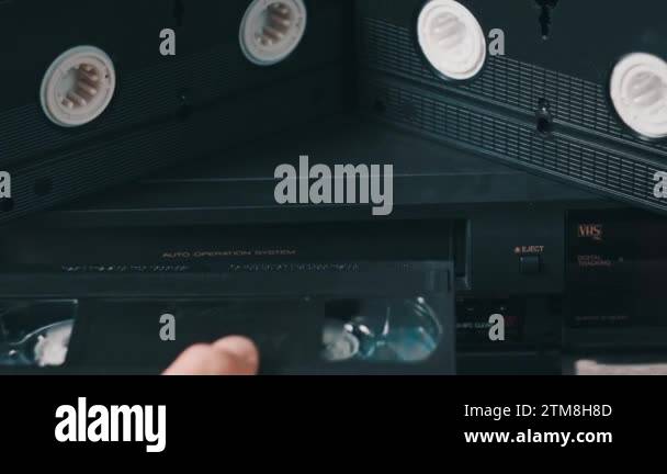 Insert VHS cassette into VCR player. Black vintage videotape cassette ...