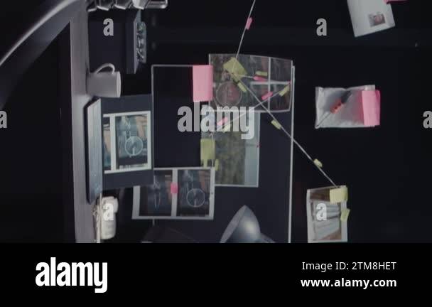 Vertical video: Private detective reviewing clues on wall board to ...