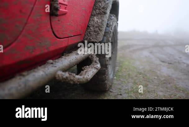 Wheel and exhaust pipe of red truck splattered with mud. Massive all ...
