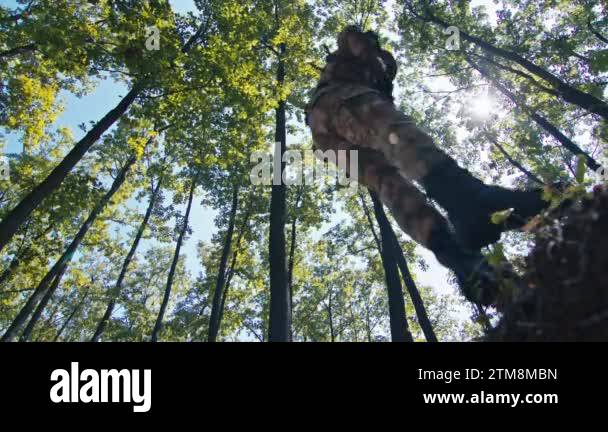 Two soldiers exhibit teamwork, jumping over a trench in a dynamic low ...