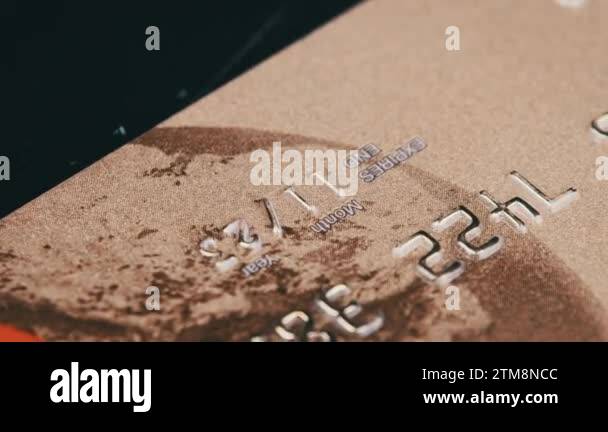Golden debit card rotates close-up. Credit card with numbers on plastic ...