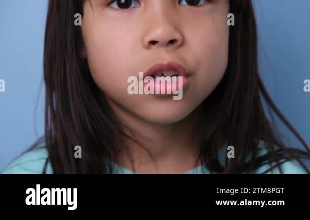 Cute little girl chewing gum on blue background. Portrait of a cute ...