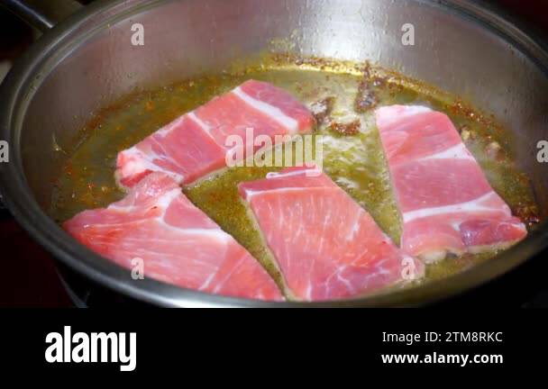 Searing beef bottom round roasted meat in cast iron skillet in boiling ...