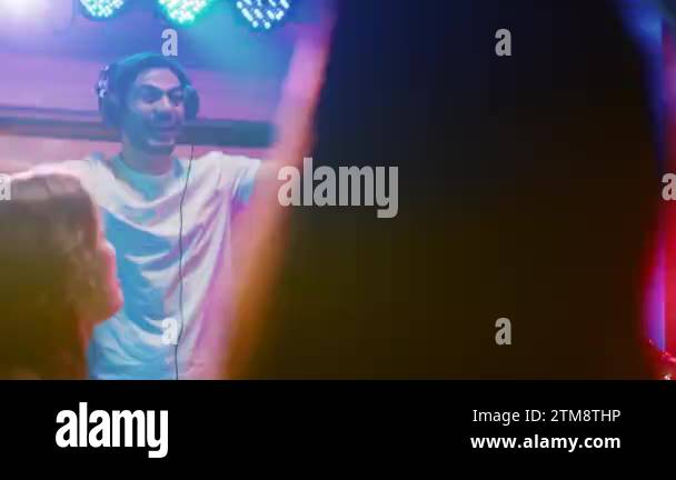 Cool DJ clubbing with people on stage, mixing electronic sounds on ...